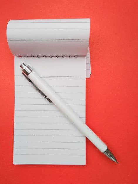 Premium Photo Note Pad And Pen On Colored Background