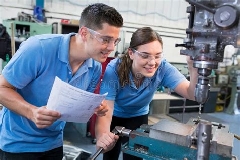 Engineer Instructing Female Apprentice On Use Of Cnc Machine Stock Image Image Of Occupation