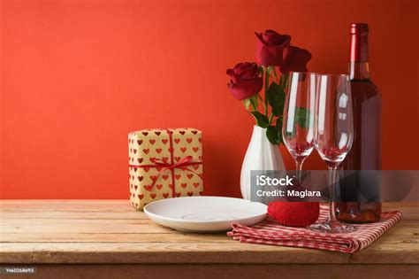 발렌타인 데이 낭만적 인 저녁 식사 개념 접시 와인 잔 선물 상자 빨간색 배경 위에 장미 꽃이 있는 나무 테이블 0명에 대한