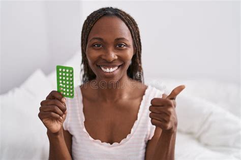 African American Woman Holding Birth Control Pills Smiling Happy And