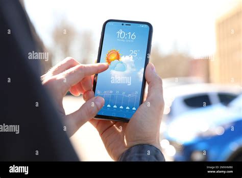 Man Using Weather Forecast App On Smartphone Outdoors Closeup Stock Photo Alamy