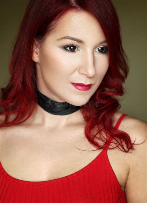 The Young Redhead Woman In Red Top With Black Ribbon On The Neck Stock