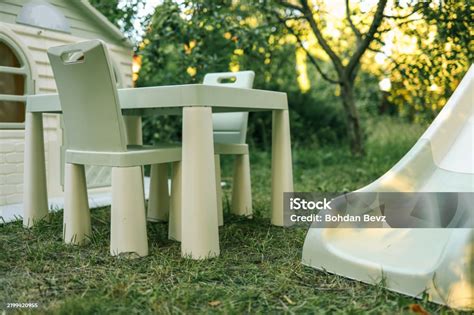 어린이용 플라스틱 테이블과 의자 그리고 작은 미끄럼틀이 극장 근처 잔디밭에 놓여 있습니다 아이들의 야외 활동 여름 모임 상상력 놀이에 적합합니다 0명에 대한 스톡 사진 및