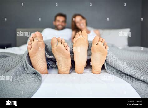 Sunday Is Bed Day A Happy Young Couple Relaxing In Bed With Their Feet
