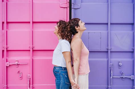 행복한 레즈비언 부부는 웃고 분홍색과 보라색 배경에 손을 잡고 사랑은 사랑입니다 Lgtbi 컨셉 2명에 대한 스톡 사진 및 기타