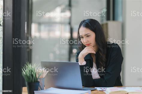 스트레스를 받고 지친 밀레니얼 세대의 아시아 사업가는 현대 사무실에서 원격으로 컴퓨터 작업을 하면서 노트북을 사용한 후