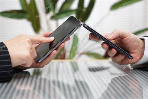 Woman And Man Transferring Files From Smart Mobile Phone To Anot Stock Photo Bacho123456