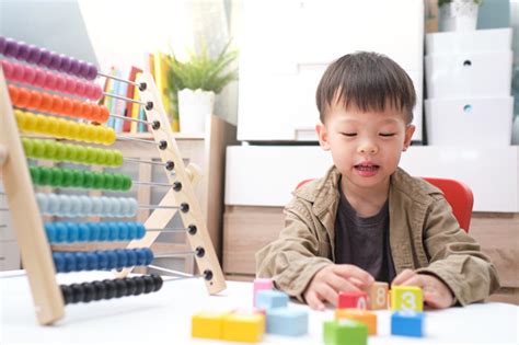 귀여운 작은 아시아 구슬과 나무 벽돌과 함께 Abacus를 사용하여 집에서 계산하는 방법을 배울 수 있습니다 어린 아이들 개념에