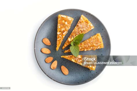 캐러멜화 멜론 구운 호두 헤이즐넛 피스타치오로 만든 전통적인 터키식 사탕 세제리는 흰색 배경에 고립된 파란색 세라믹 플레이트에