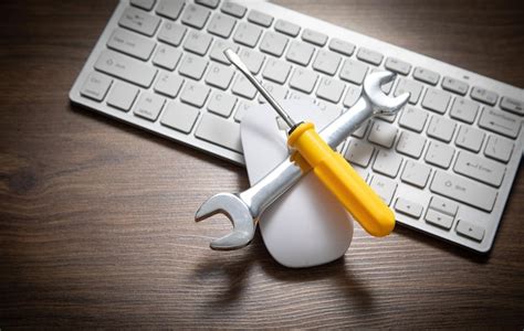 Premium Photo Wrench And Screwdriver With A Computer Keyboard It