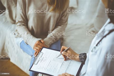 실내에 앉아있는 동안 현재 건강 검진을 논의 하는 알 수 없는 여성 의사와 환자 코로나바이러스 전염병 및 자기 격리 검역 중 홈