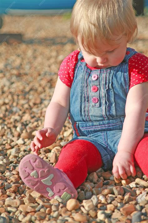 Premium Photo Cute Girl Lying On Pebbles