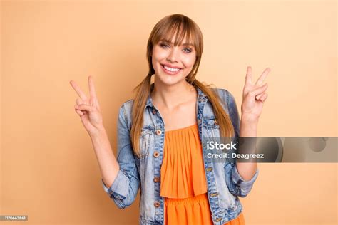 귀여운 사랑스러운 좋은 젊음의 초상화 는 V징후는 휴가 이빨이 그녀 잘 생긴 옷을 입은 오렌지 스커트 드레스 고립 파스텔 베이지