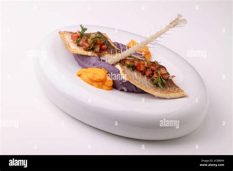 Sea Bass Fillet With Purple Potato Puree Carrot Puree And Tomato Salsa