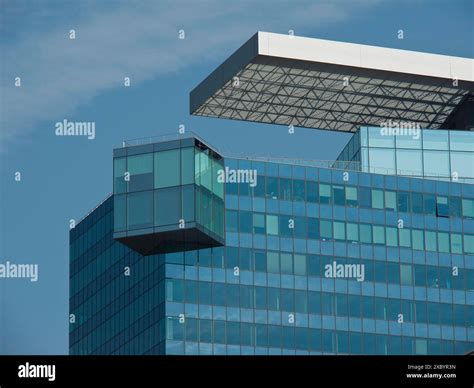 A Modern Glass Building With A Striking Glass Structure Protruding From