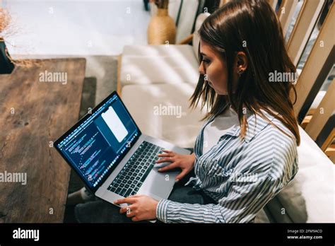 Young Woman Mobile Developer With Laptop Writes Program Code On A Computer Programmer Work In