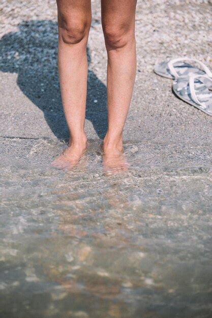 Premium Photo Low Section Of Woman Standing On Shore At Beach