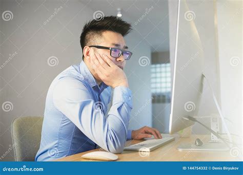 Young Asian Man Programmer Wearing Shirt And Glasses Working While