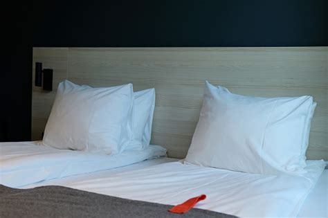 빈 침대 옆 탁자가있는 침실 조각 독서 램프와 현대적인 인테리어 디자인 집이나 호텔의 소켓을 끕니다 부드러운 베개와 담요 세련된