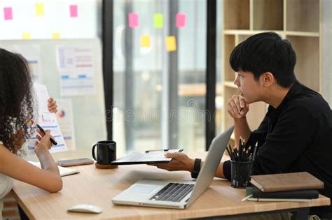 Two Colleagues Collaborating On Business Strategies In Bright Office