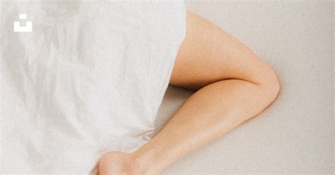 Eine Person Die In Einem Bett Mit Einem Weißen Laken Liegt Foto