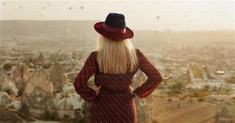 여행하다 하늘에서 열기구를 날고 있는 언덕에 모자를 쓴 아름다운 여자 카파도키아로 여행하는 여성 고해상도 사진 Unsplash의 모자 이미지