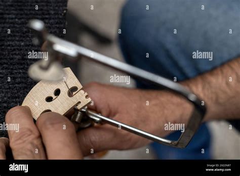 Top View Of Unrecognizable Latin American Luthier Using A Hacksaw To Finish Making A Violin