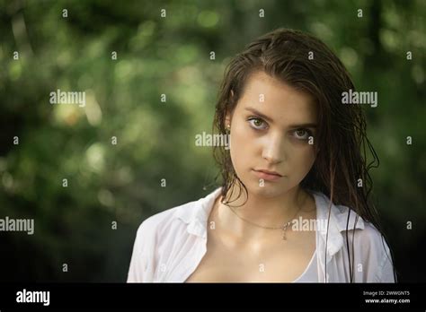 Portrait Of A Young Brunette With Wet Hair Posing In A White Wet Shirt