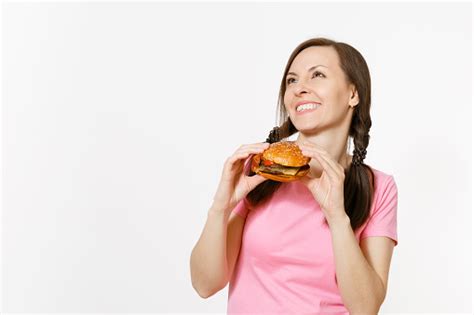 분홍색에서 젊은 아름 다운 여자 T셔츠에 머리 띠와 흰색 배경에 고립 햄버거 손 적절 한 영양 섭취 또는 고전적인 미국의 패스트 푸드입니다 광고에 대 한 공간을 복사 합니다