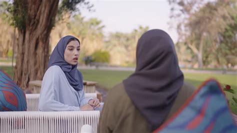 Two Saudi Arab Gulf Women Sitting In A Public Garden In The Open Air