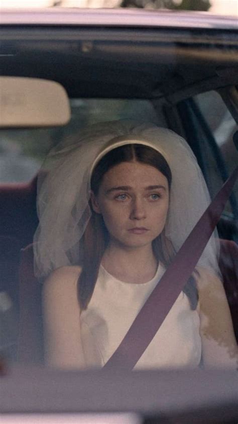 A Woman Sitting In The Back Seat Of A Car With A Veil On Her Head