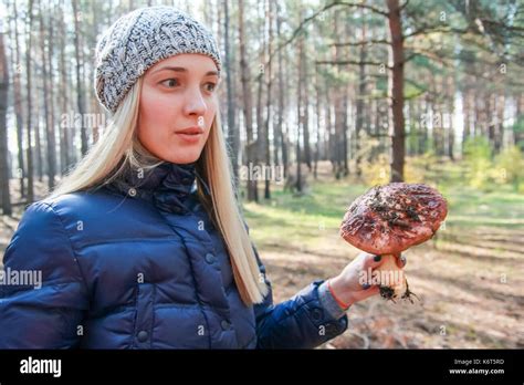 Beautiful Blonde Woman Holding A Huge Porcini Cep Mushroom At A Pine