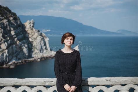 Jolie Femme Se Tenant Sur Un Balcon Avec La Belle Vue Sur Le Fond Photo
