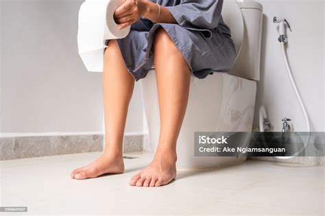 Woman Sitting On The Toilet Bowl In The Bathroom She Has Stomach Ache