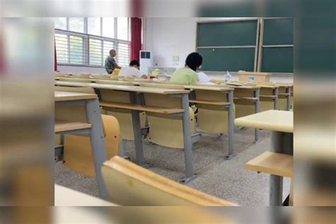 工人进学校自习室避暑依靠在桌子上打量教室若有所思 避暑 桌子 教室
