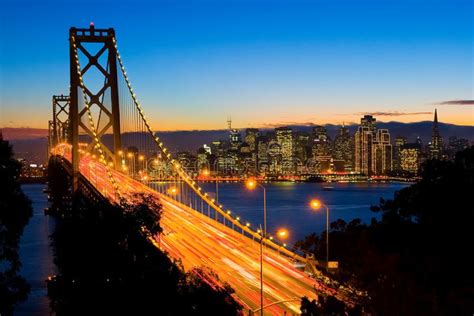 San Francisco And Bay Bridge At Night With Christmas Lights Around The