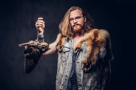 긴 무성 한 머리와 전체 수염 Tattoed 레드 Hipster 남자의 T셔츠를 입고 자 켓 스튜디오에서 어깨에 올빼미와 여우