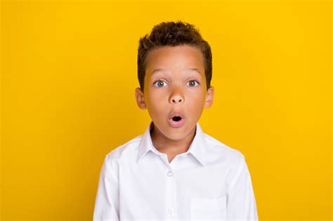 놀란 말문이 막히고 쳐다보는 소년 사람이 흰 옷을 입고 입을 벌리고 노란색 배경에 고립 된 사진 아이에 대한 스톡 사진 및 기타 이미지 Istock