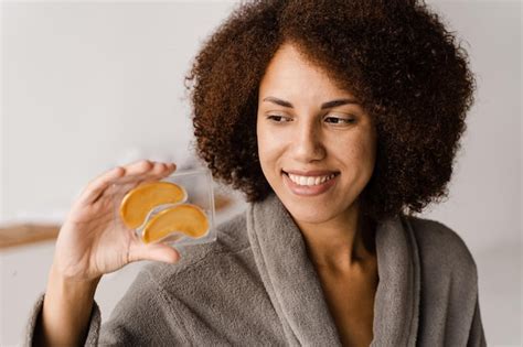 Premium Photo African Woman Holding Gold Eye Patches For Smoothing