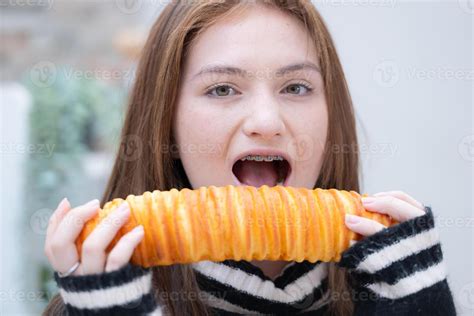 Portrait Of Teenage Girl Eating Bread In The Kitchen At Home 38077301