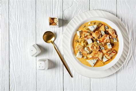 독일 요리 크림 피클 블루 몰드 치즈를 곁들인 돼지고기 스튜 흰 나무 배경에 황금 숟가락이 달린 흰색 접시에 훈제 파프리카 상단 보기 클로즈업 0명에 대한 스톡 사진 및