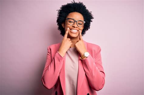 젊은 아름다운 아프리카계 미국인 Afro 사업가 곱슬 머리 를 입고 핑크 재킷 미소 와 열린 입 손가락 가리키는 및 강제 쾌활한