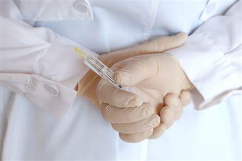 예방 접종 개념 의학 및 건강 개념 코로나 바이러스 백신 의사는 등에 주사기를 손에 들고 있다 흰색 의료 코트와 주사기