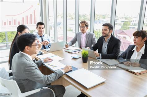 미소와 행복한 얼굴로 만나는 다민족 비즈니스 사람들의 화이트 보드에서 성공 비즈니스 이익 그래프를 보여주는 백인 사업가 개념에