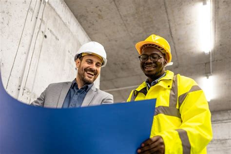 Premium Photo Construction Worker And Civil Engineer Analyzing Blueprints Of The Building Project