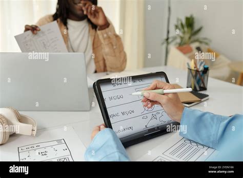 Diverse Group Collaborates On Ui Design Projects In Modern Workspace Sketching Ideas On Digital