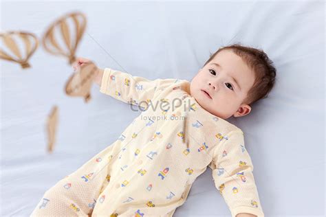 침대에 누워서 놀고있는 귀여운 아기 사진 무료 다운로드 Lovepik