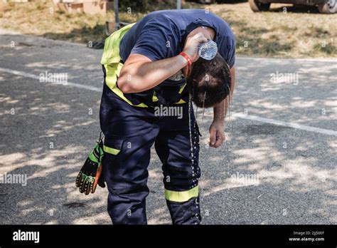 A Heat Exhausted Fireman Douses His Head With Water As Temperatures In