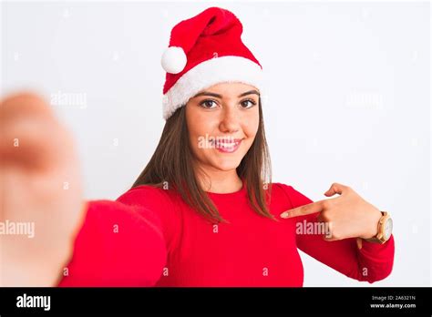 Girl Wearing Christmas Santa Hat Make Selfie By Camera Over Isolated