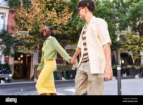 From Below Confident Young Multiethnic Couple In Stylish Outfits And